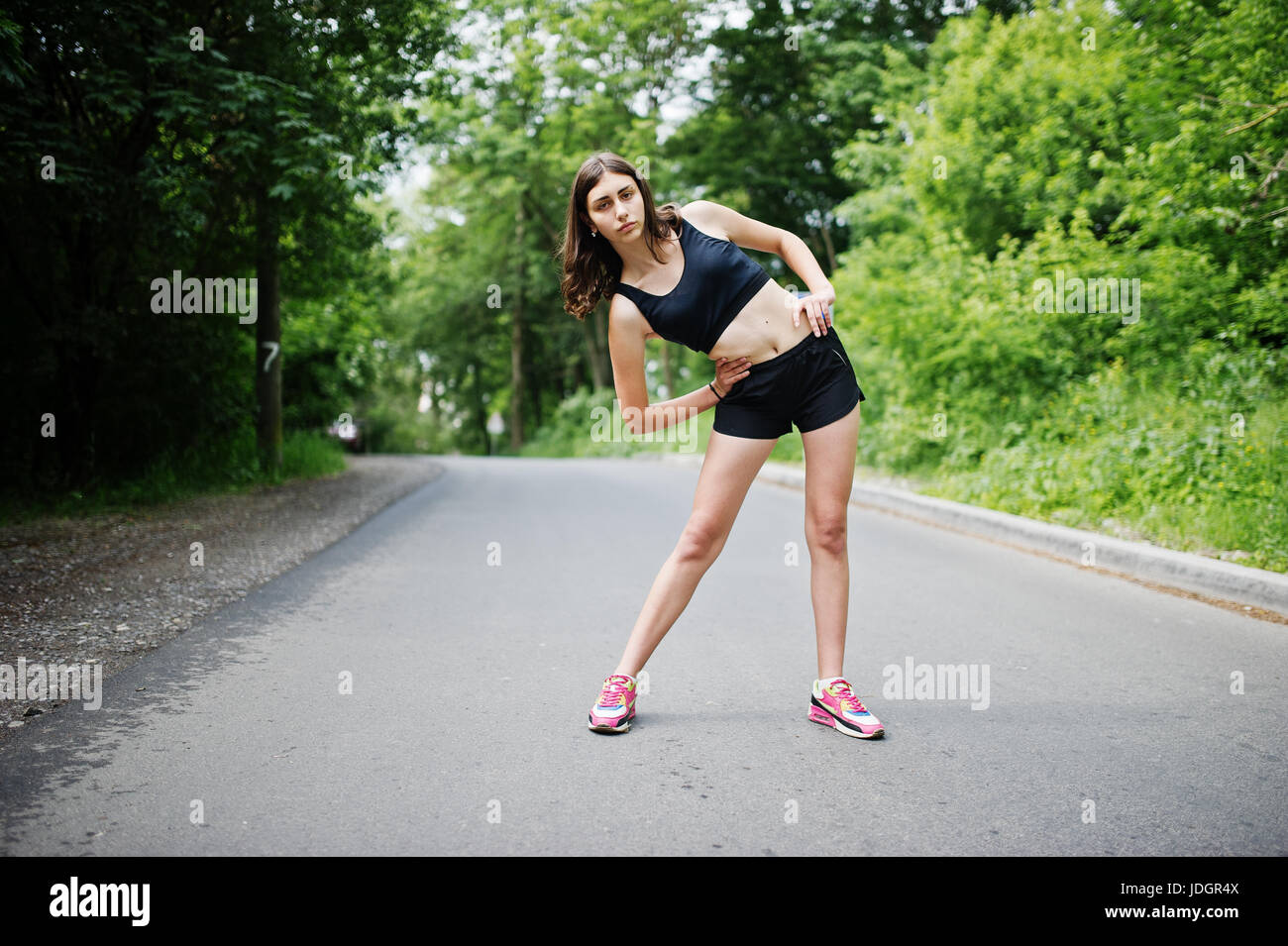 Sport girl at sportswear exercising in a green park and training at ...