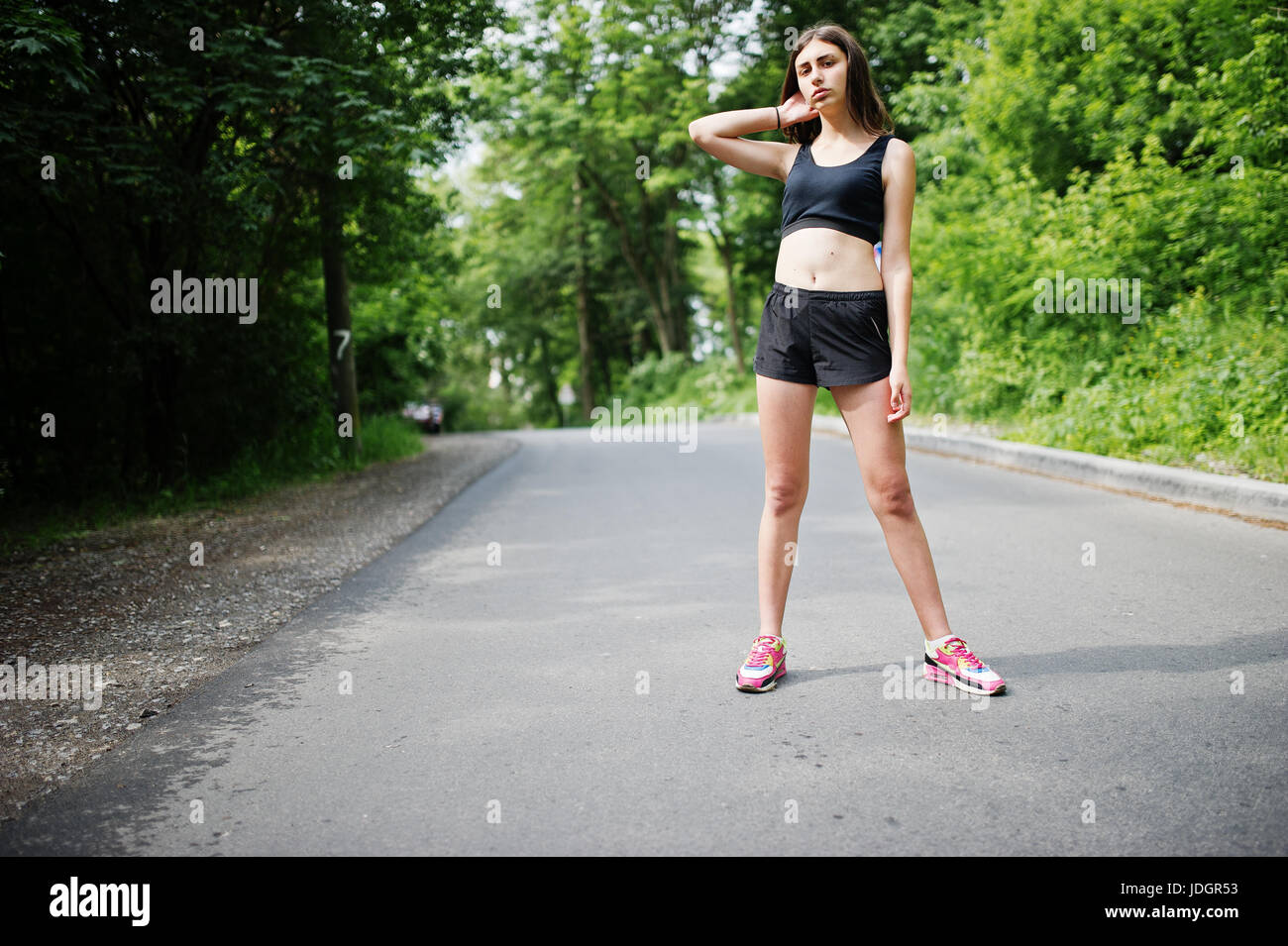Sport girl at sportswear exercising in a green park and training at ...