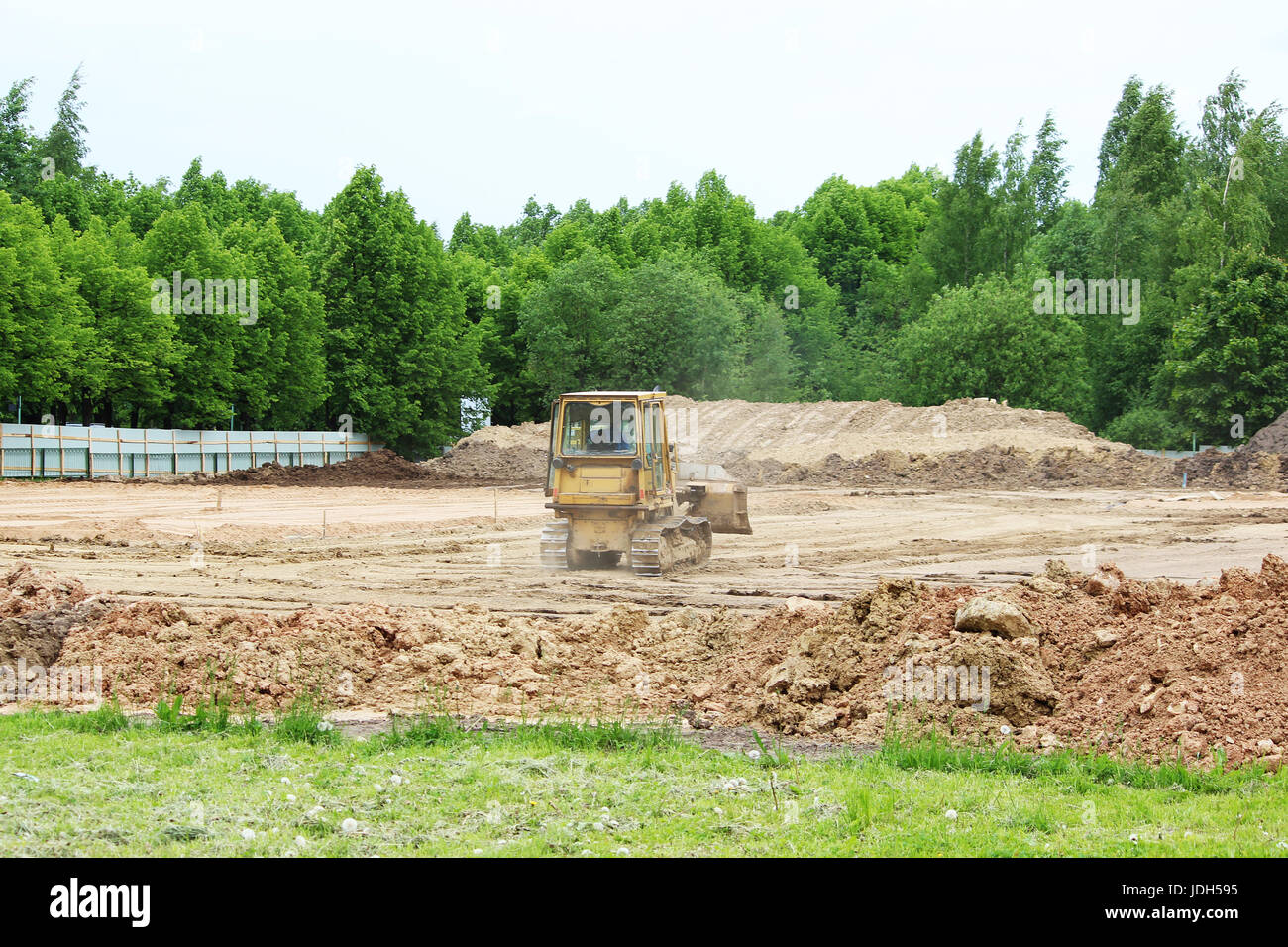 tractor and compactor are leveling and compacting the surface of the ...