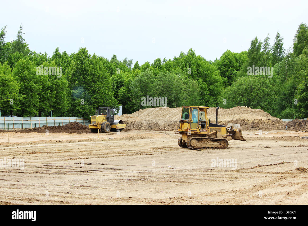 tractor and compactor are leveling and compacting the surface of the ...