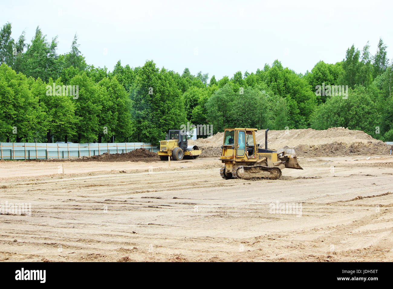 tractor and compactor are leveling and compacting the surface of the ...