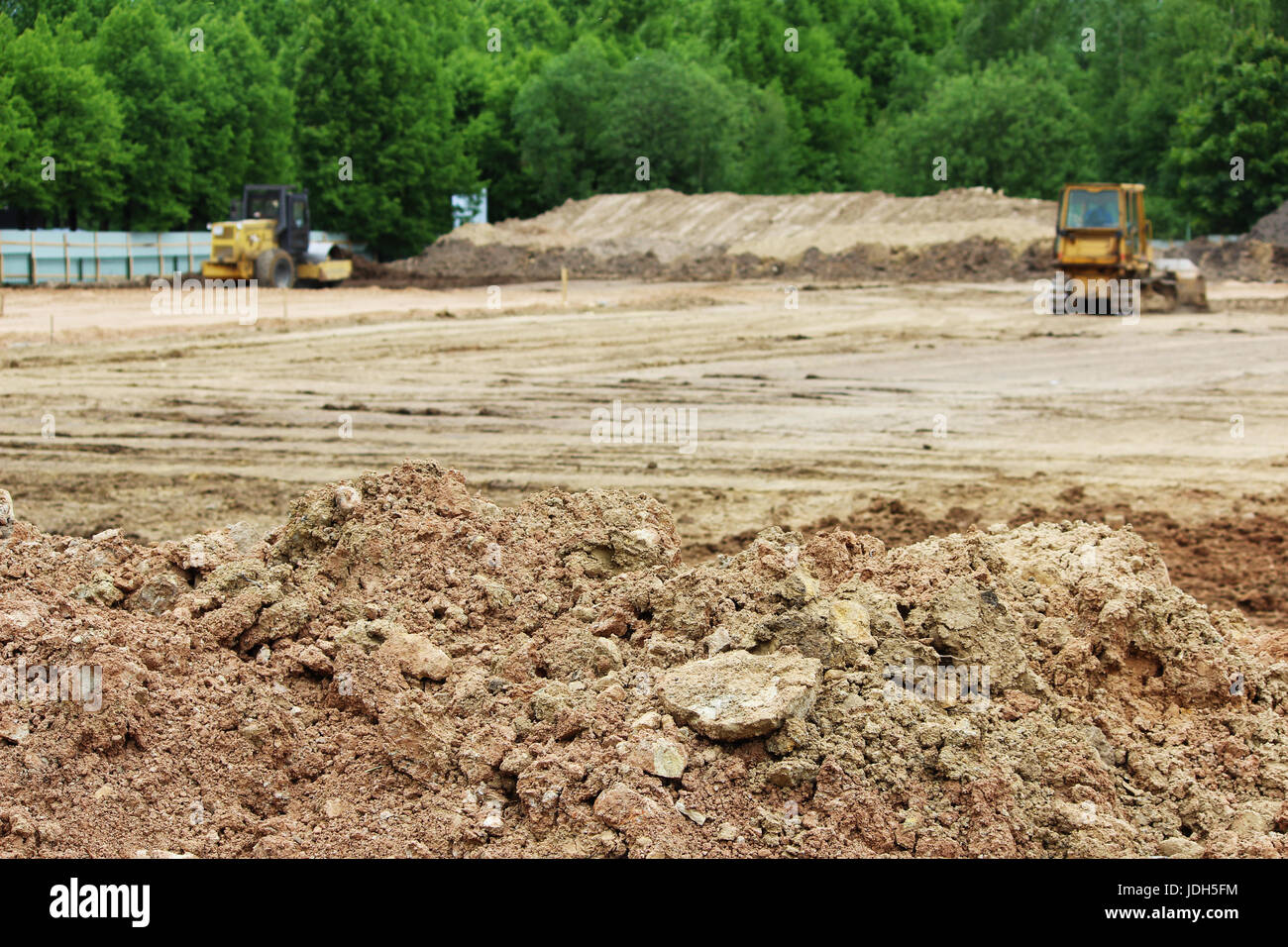 tractor and compactor are leveling and compacting the surface of the ...