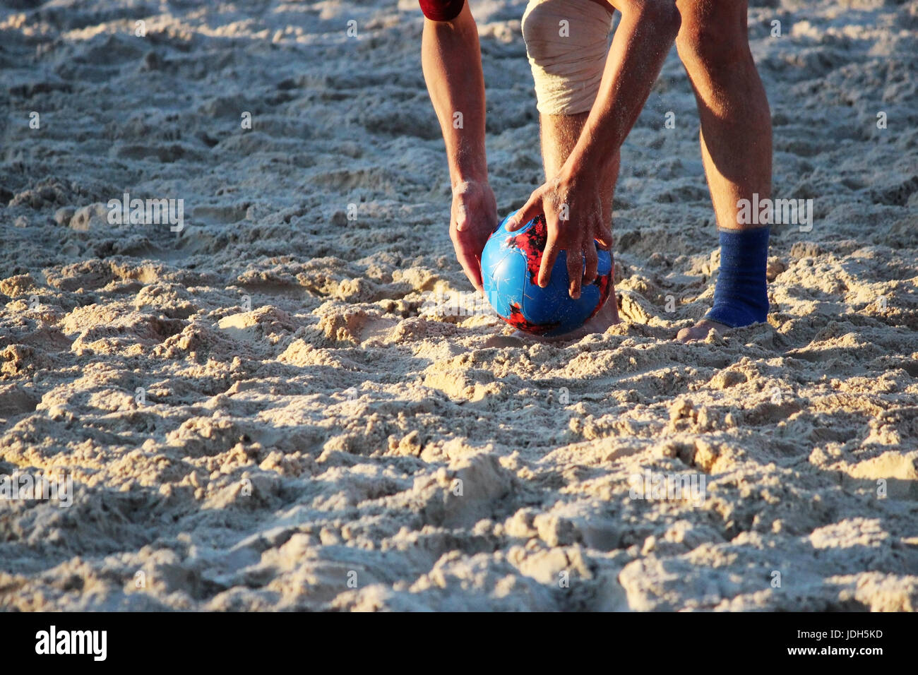 Young men play soccer in the summer on the sand platform Stock Photo ...