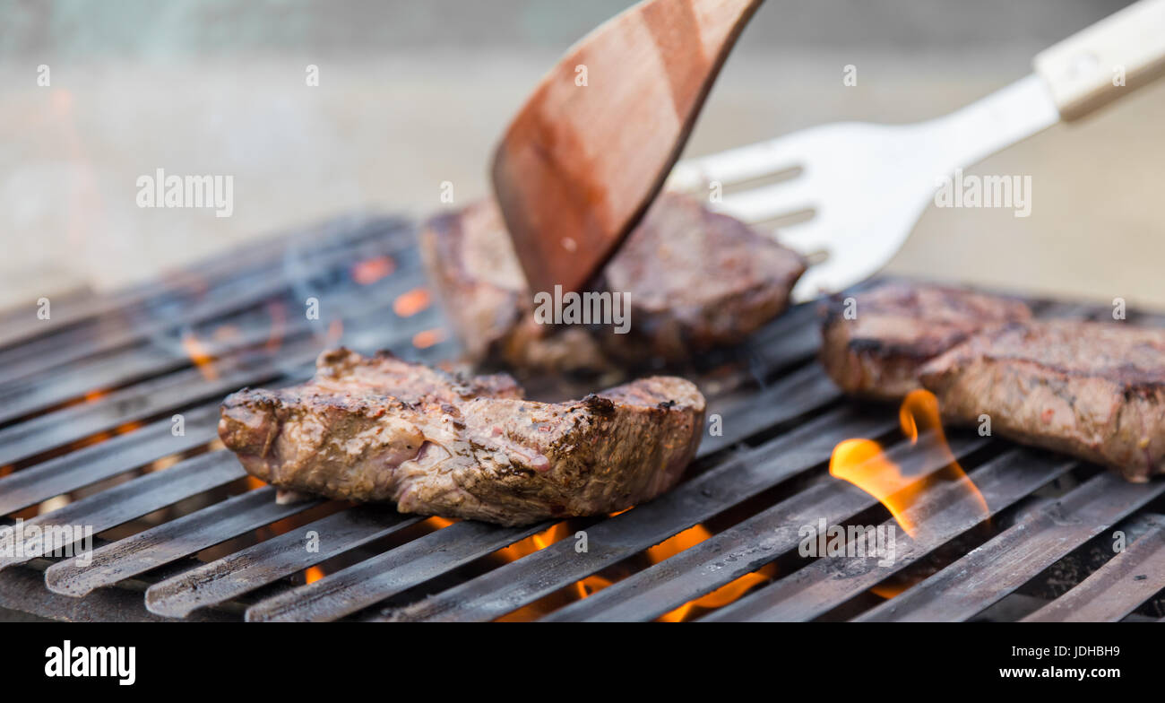 Chef grilling a beef steak on open flame BBQ Stock Photo - Alamy