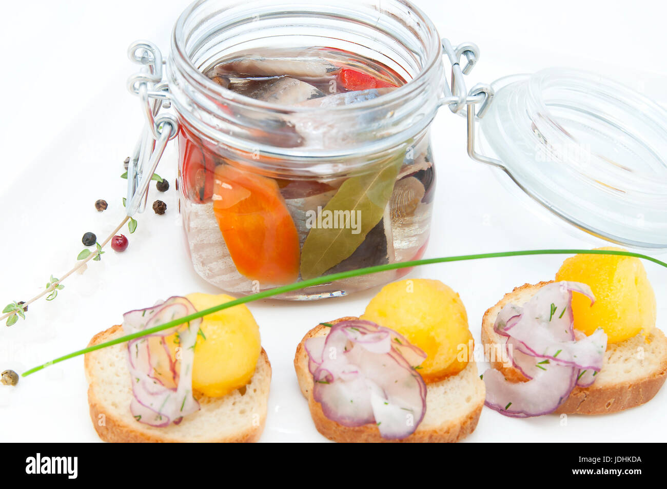 Pickled herring in a glass jar with potato canapes Stock Photo - Alamy