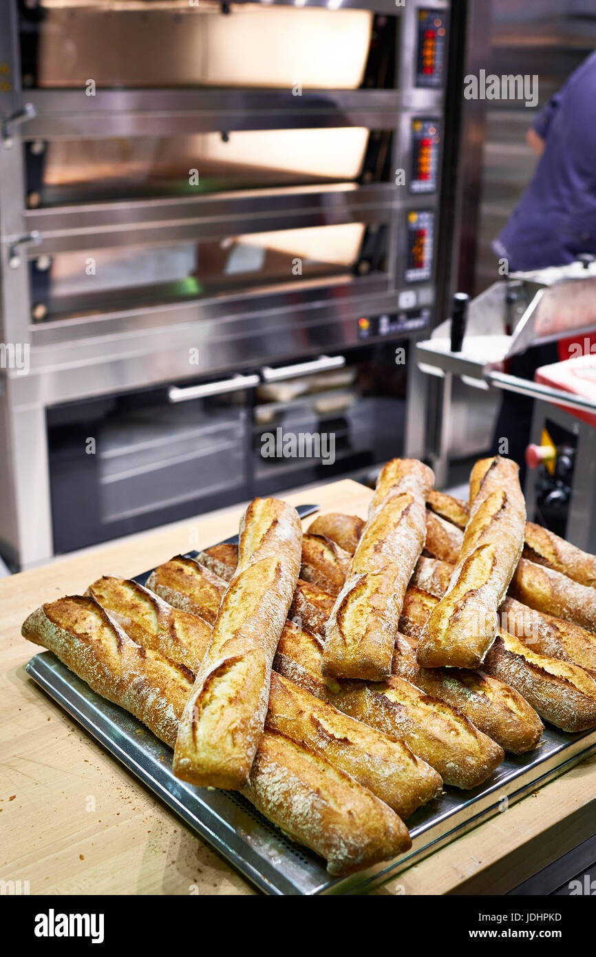 Fresh baguette bread and oven in bakery closeup Stock Photo - Alamy
