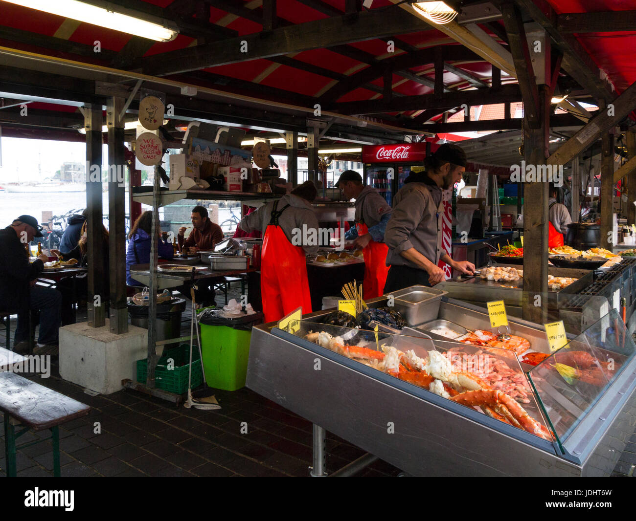 Stall in the iconic Bergen Fish Market with tourists dining on ...