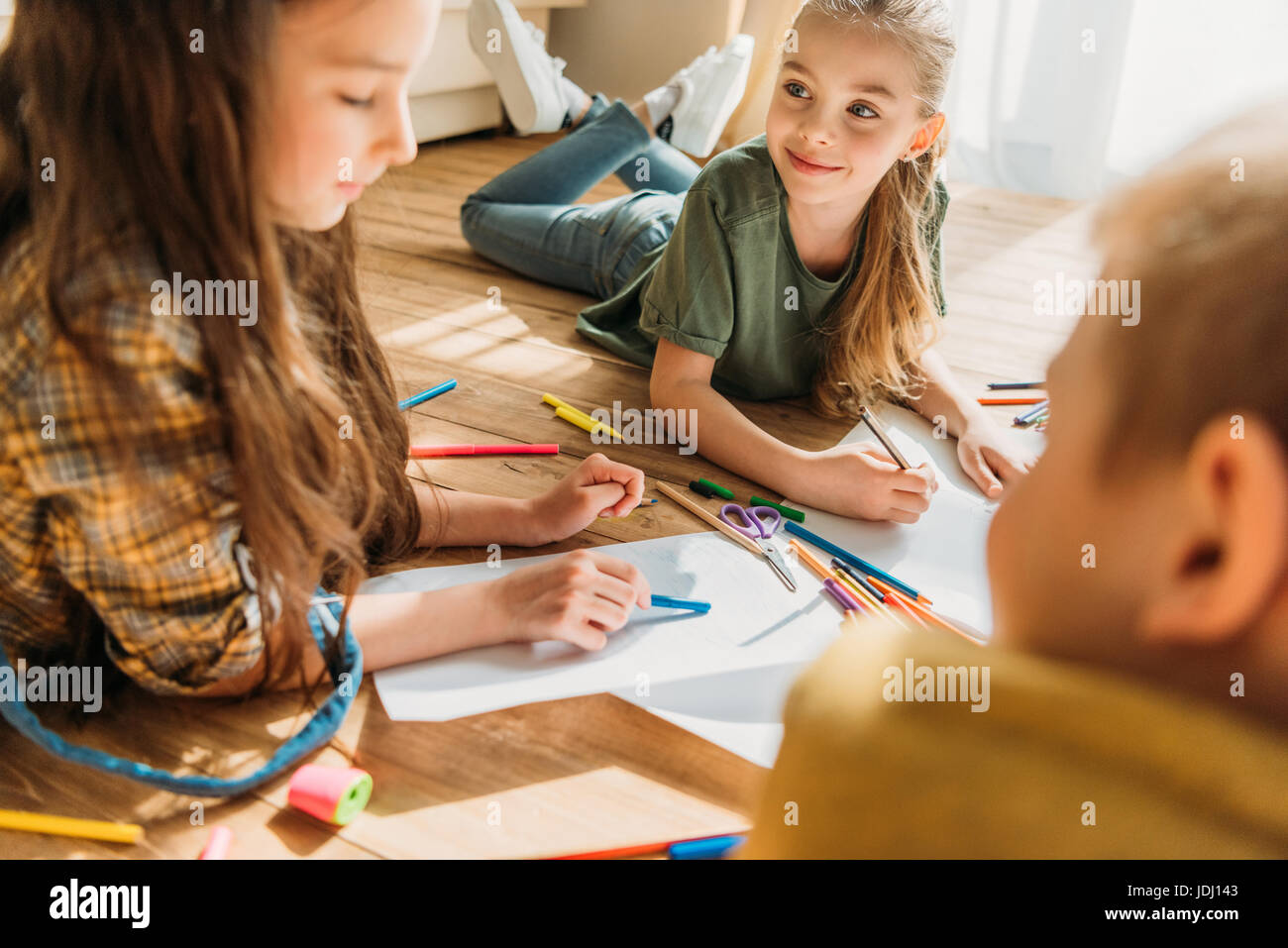cute kids drawing on paper with pencils while lying on floor Stock ...