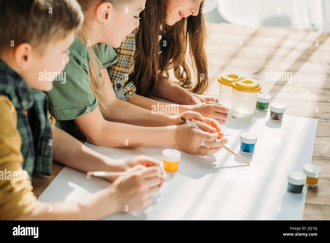 cute kids painting on paper with while lying on floor at home Stock ...