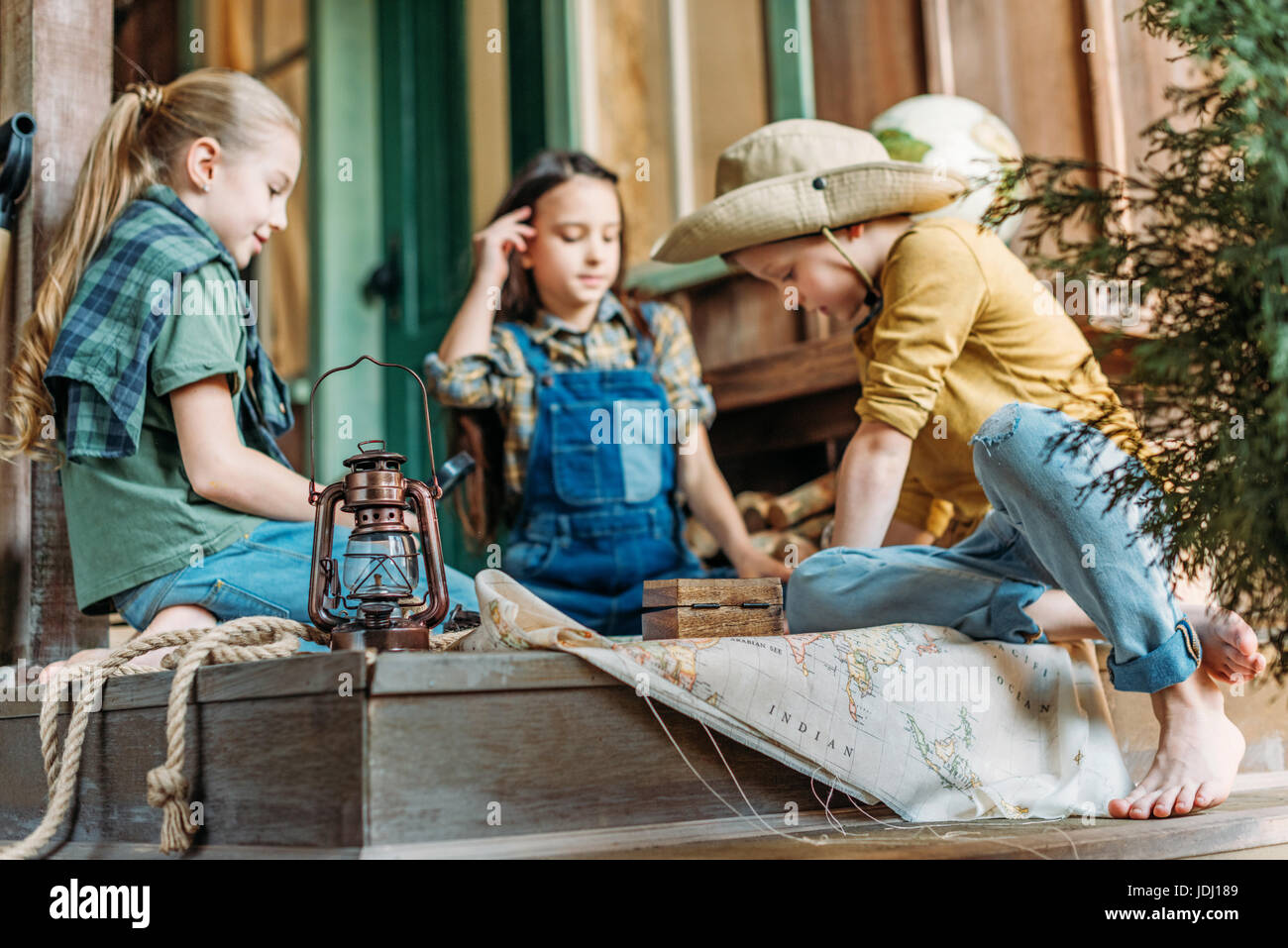 cute kids playing treasure hunt with map on porch Stock Photo - Alamy