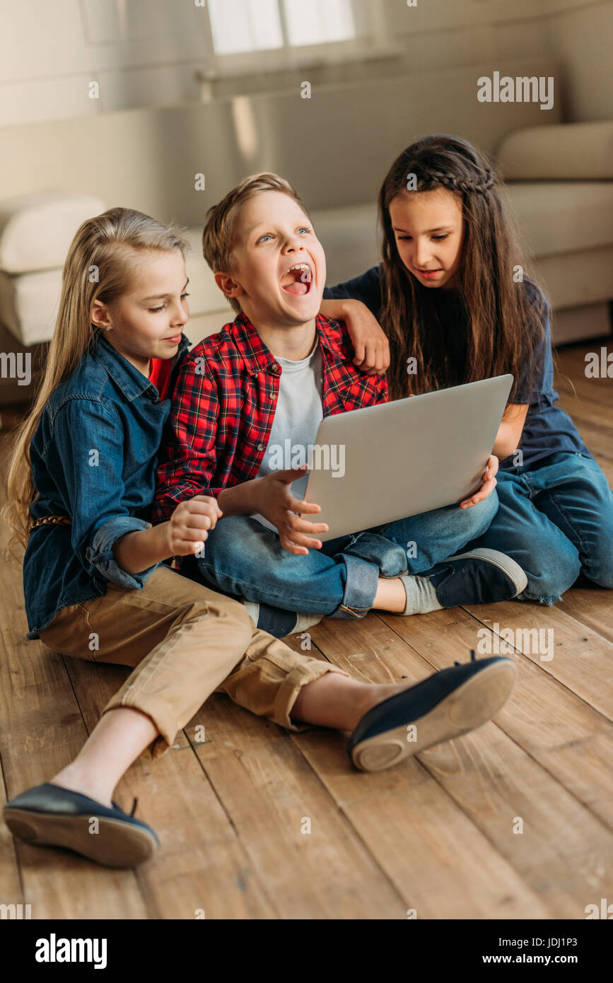 side view of boy and girls using digital laptop at home Stock Photo - Alamy
