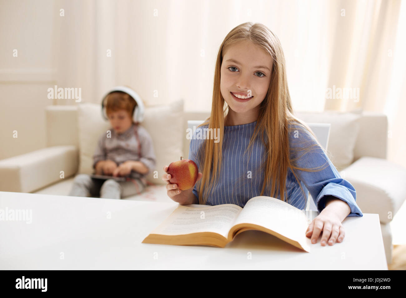 Persistent active girl working on her home assignment Stock Photo - Alamy