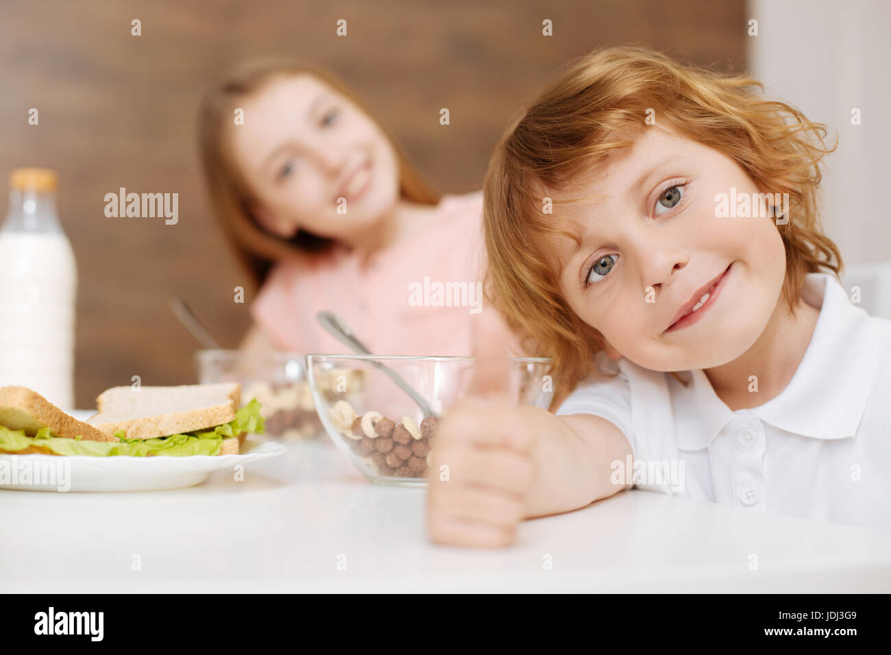 Delighted beautiful children having some sweet cereal for breakfast ...