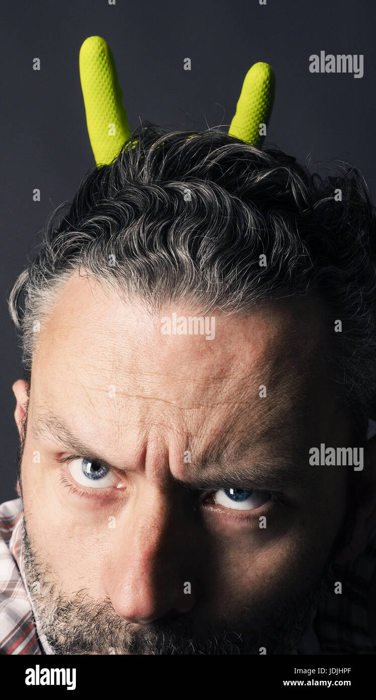 Angry man with grin on his handsome bearded face hand with rock metal ...