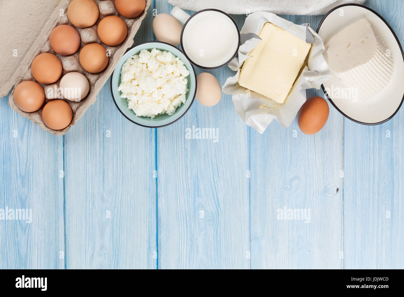 Dairy products on wooden table. Milk, cheese, egg, curd cheese and ...