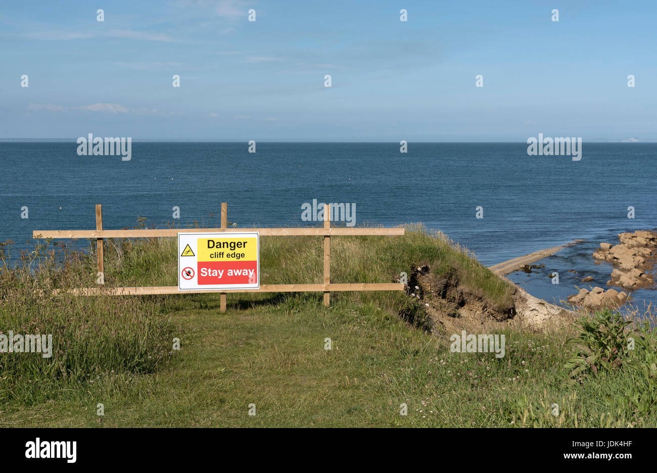 Danger signs on the cliff edge at Peveril Point in Swanage Bay Dorest ...