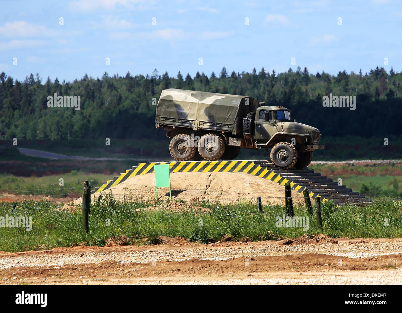 Military all terrain truck on a march over rough terrain with barriers ...