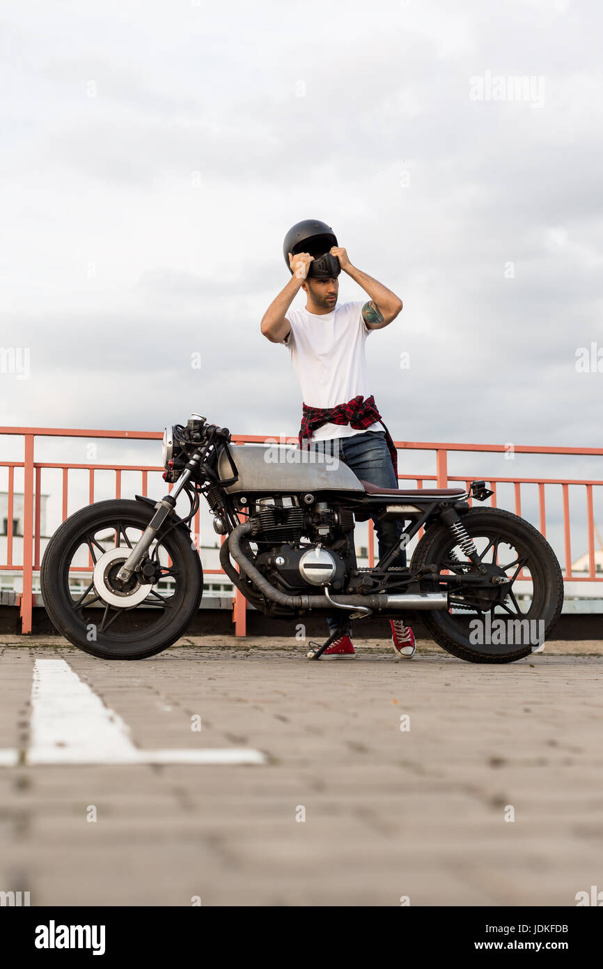 Handsome happy rider man with beard and mustache take off black moto ...