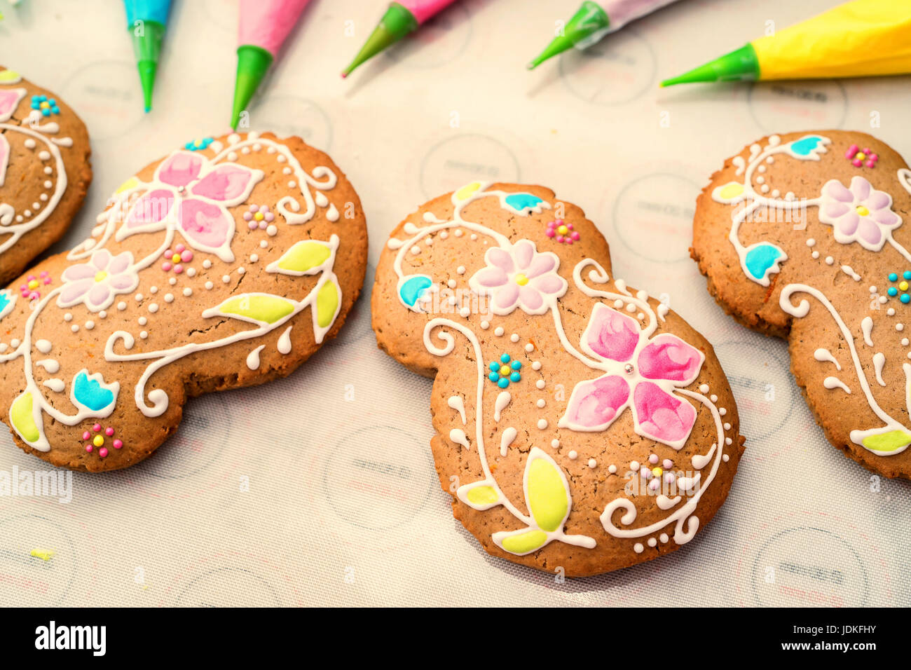 Making holiday gingerbread. Decorating gingerbread with food coloring ...