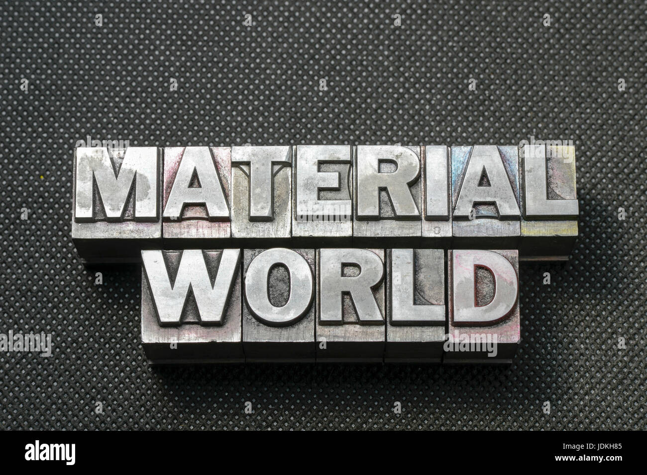 material world phrase made from metallic letterpress blocks on black ...