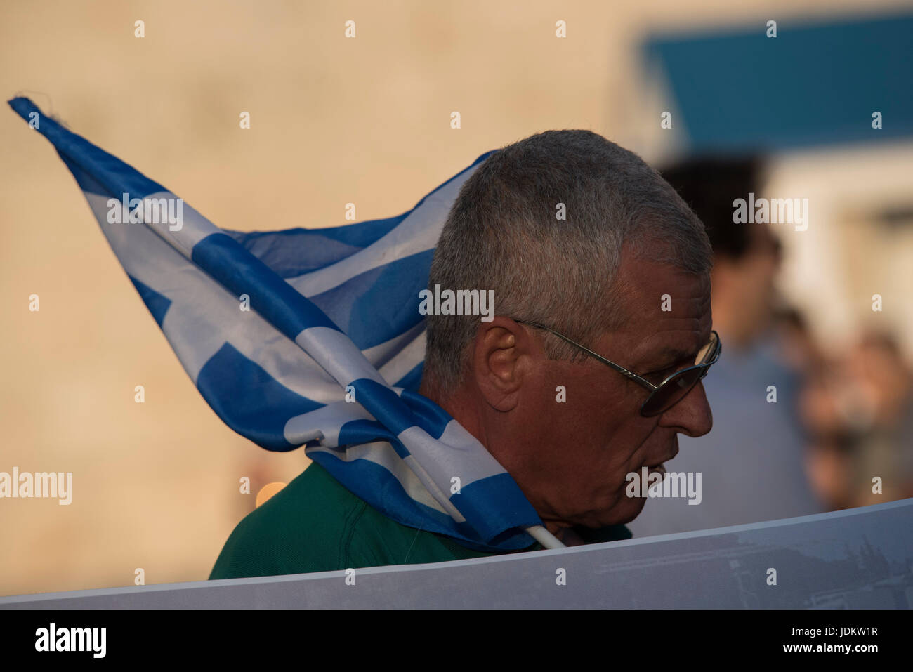 Protesters wave Greek flags and placards as they shout slogans. More ...