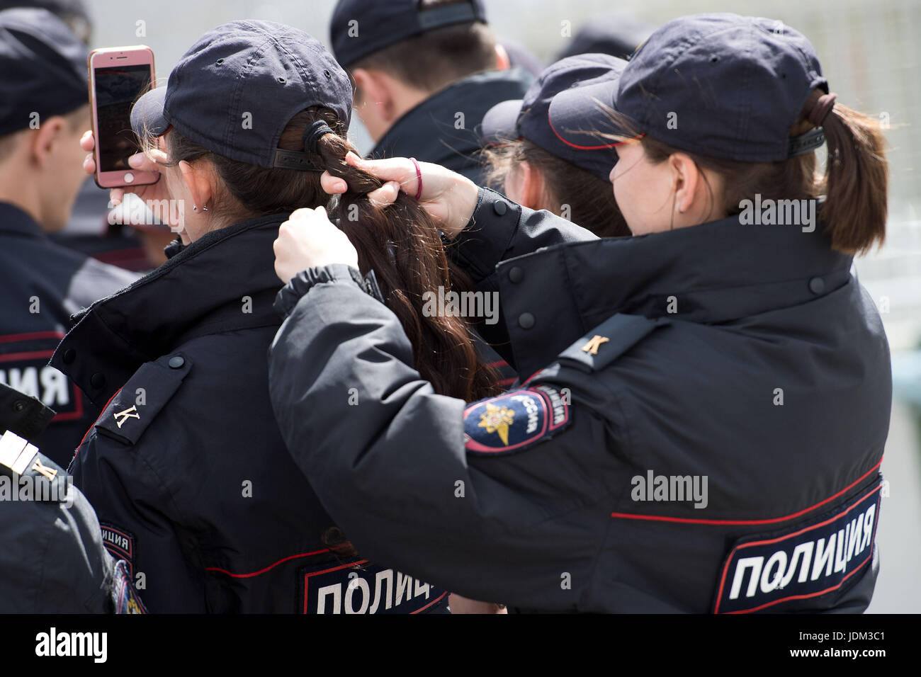 Moscow, Russia. 21st June, 2017. A police officer braids the hair of a ...