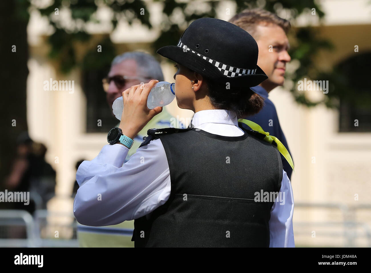London, UK. 21st Jun, 2017. A police officer drinks water on a hot and ...