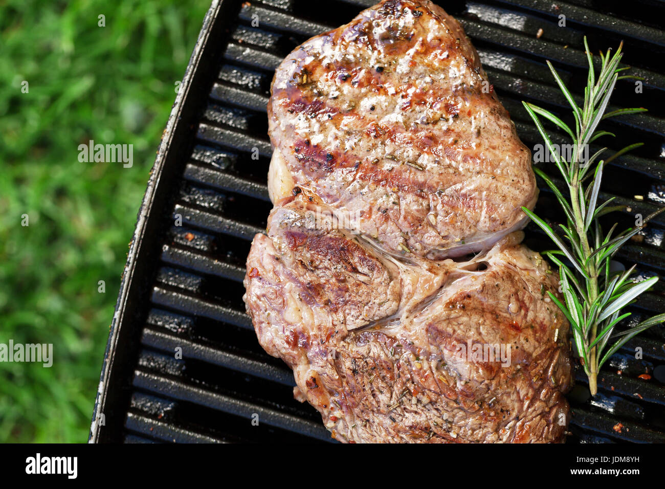 Grilled beef steak with rosemary cooking. Top view Stock Photo - Alamy