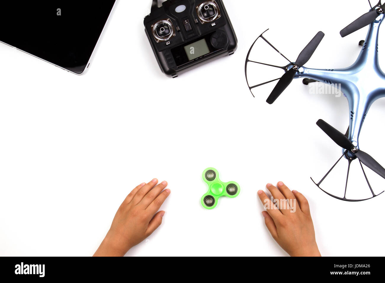 Kids hands, fidget spinner toy, drone, remote controller and tablet ...