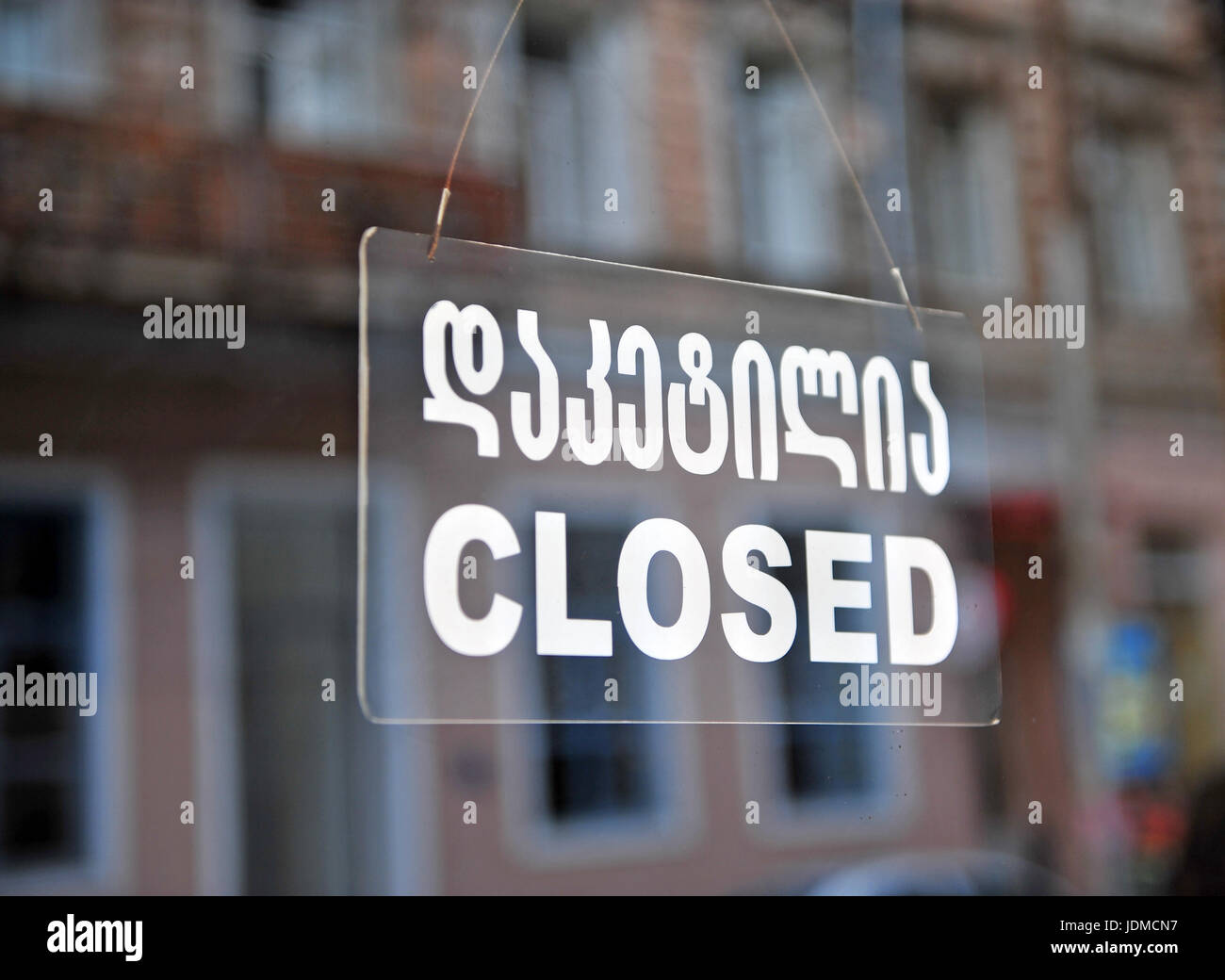 The Closed sign in geogrian and english languages Stock Photo - Alamy