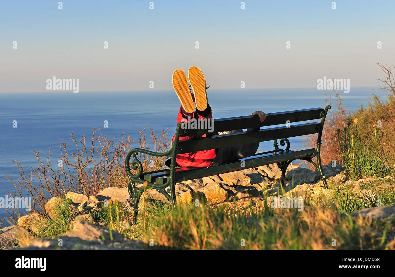 Feet in the air, man lying on the bench at the sea Stock Photo - Alamy