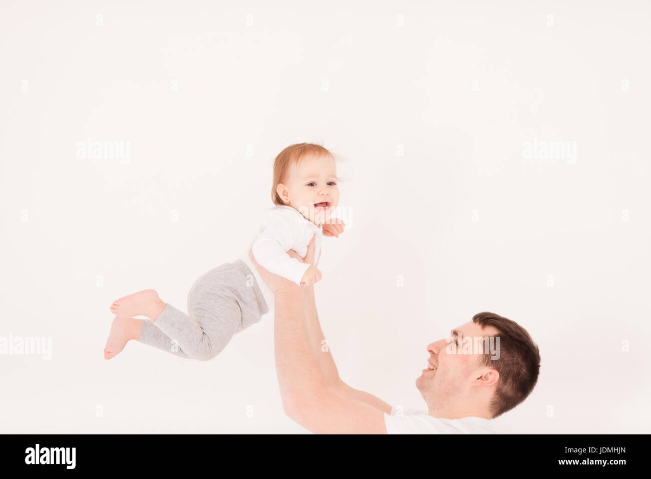 Young father lifts up his little baby girl, isolated on white Stock ...