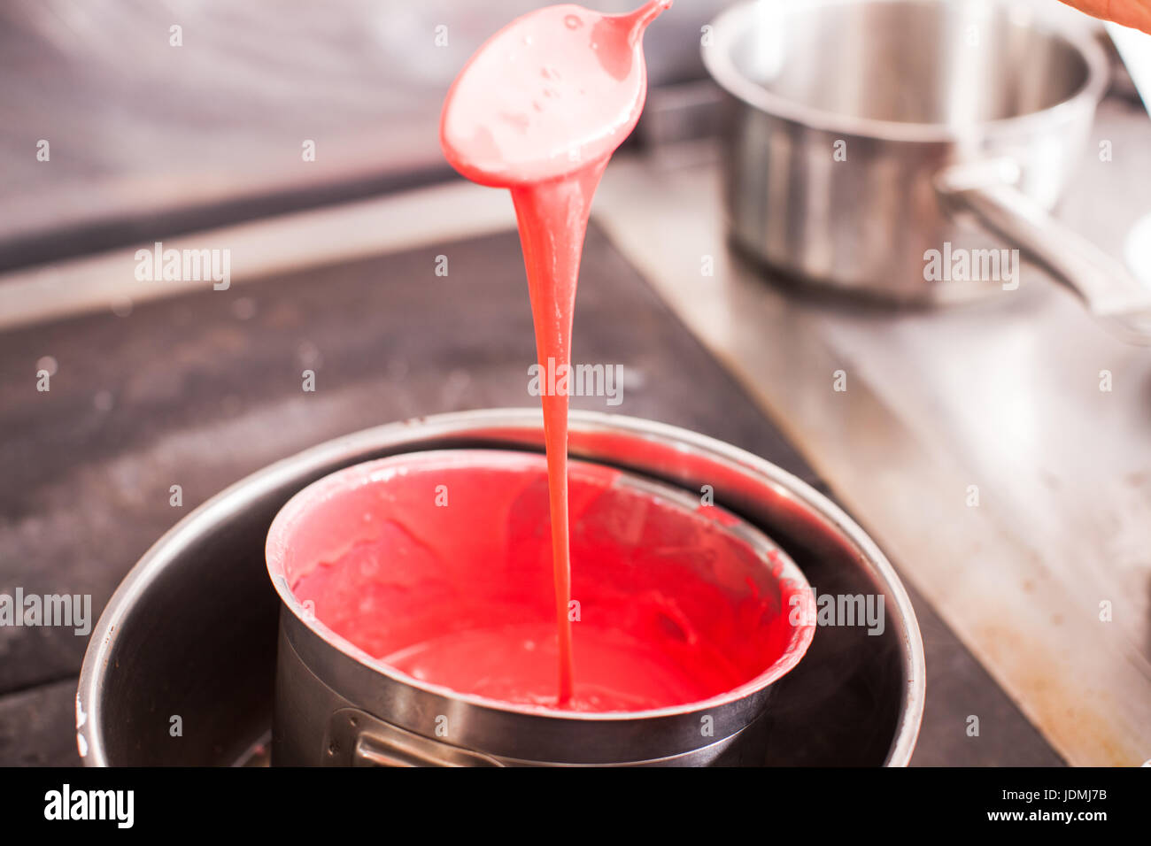 Cooking mirror glaze, red liquid in the pan Stock Photo - Alamy