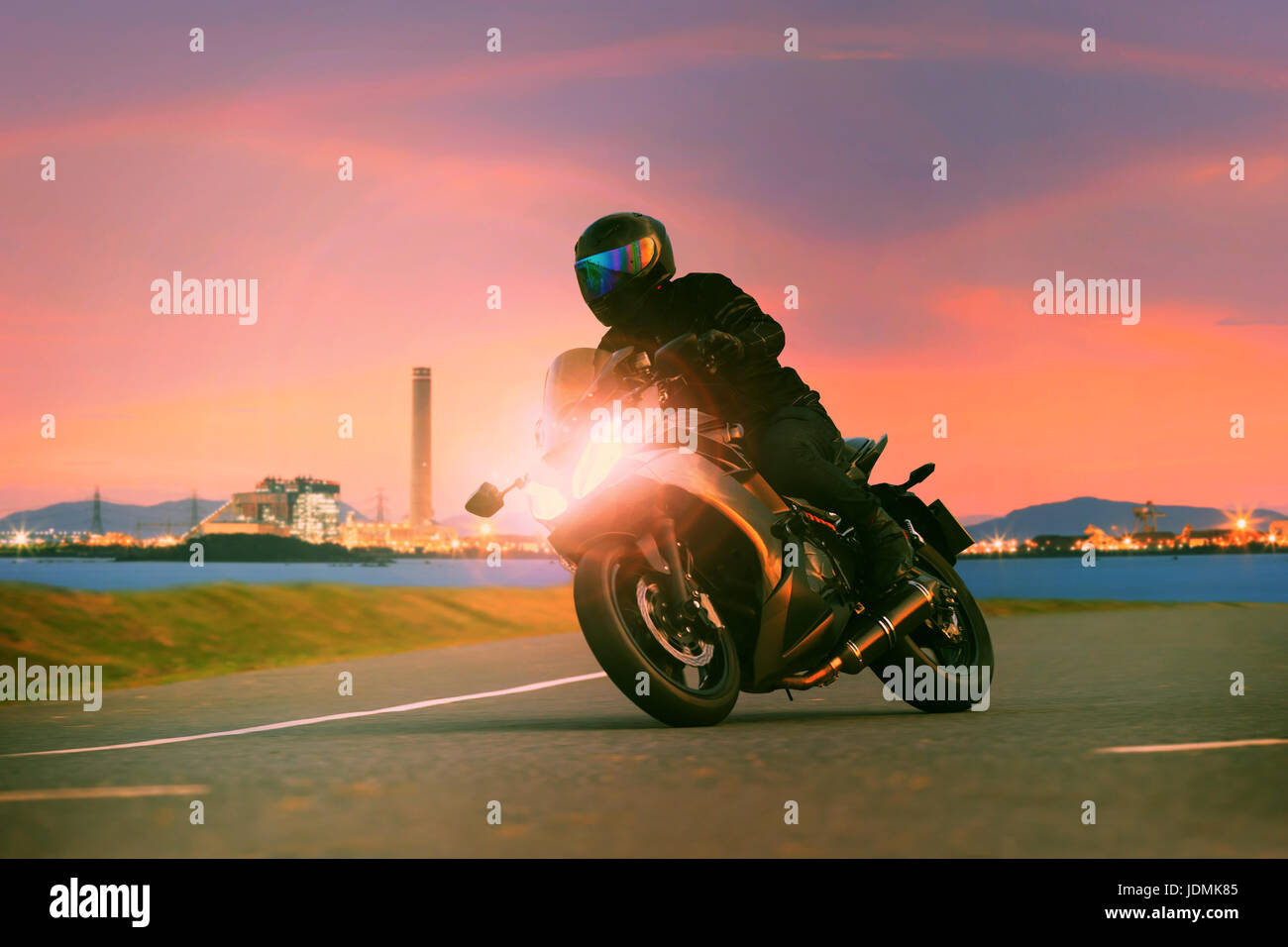 young man riding sport touring motorcycle on asphalt highways against ...