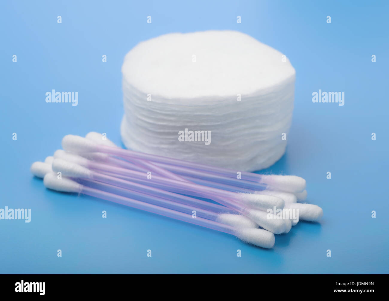 Cotton pads and buds on blue background Stock Photo - Alamy