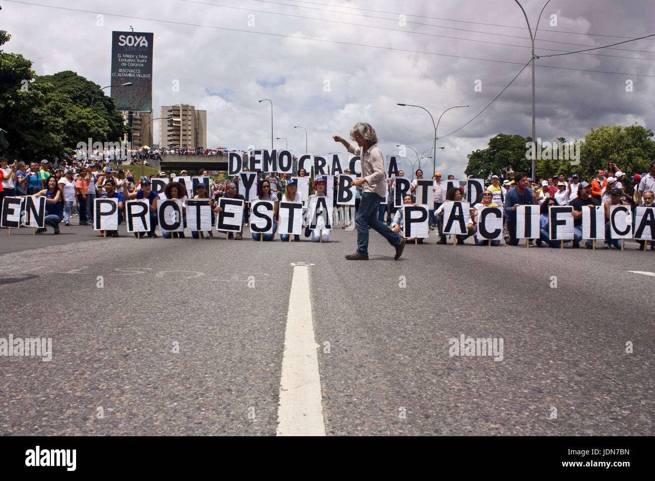 People using cardboard signs protest peacefully on a highway in Caracas ...