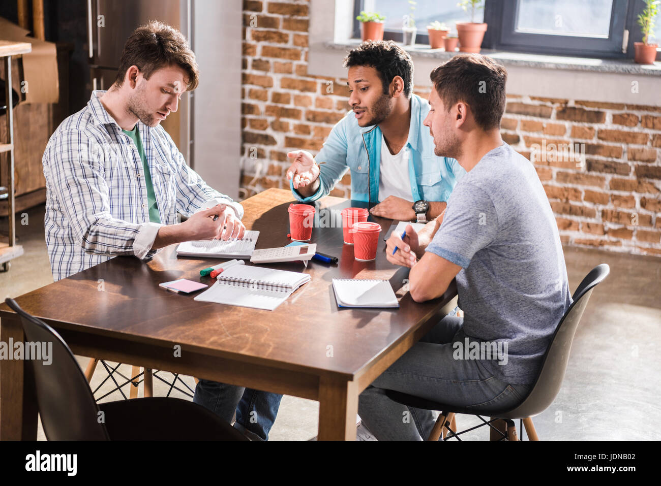 Group of young professionals working on business project together Stock ...