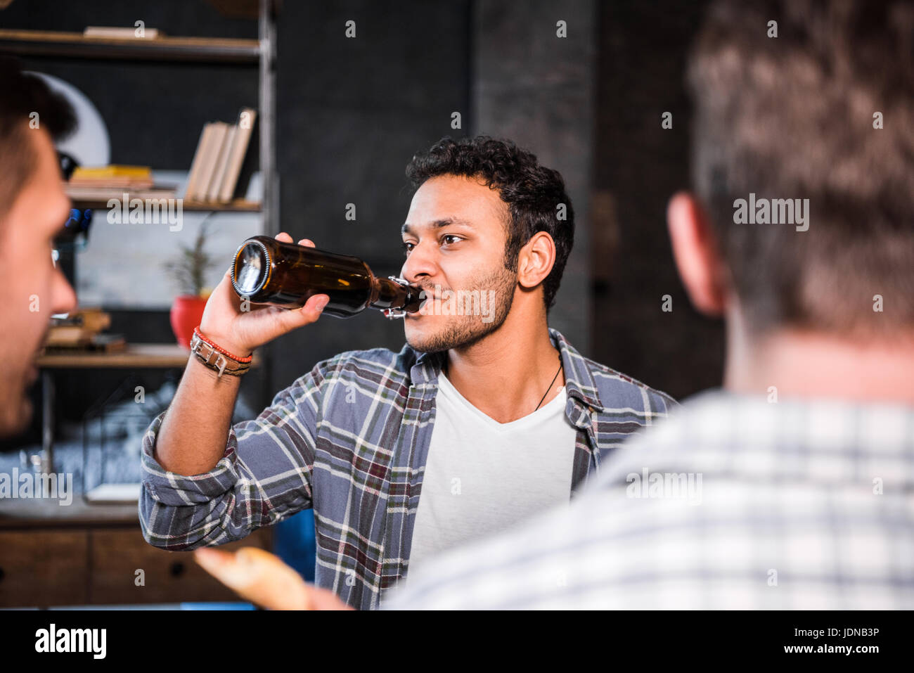Group of young people having fun and drinking beer at home Stock Photo ...