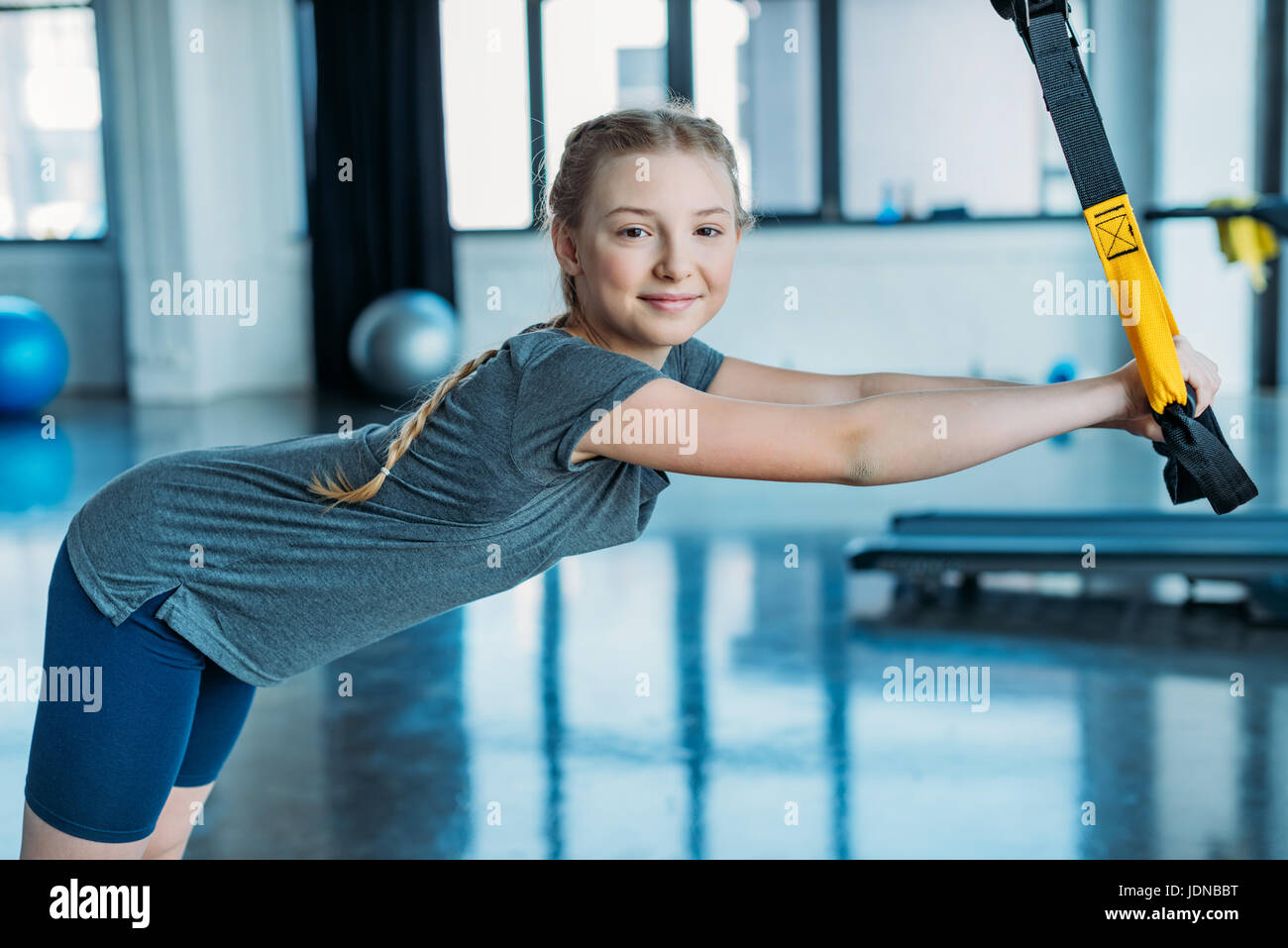 preteen girl training with resistance bands in fitness class. gym class ...