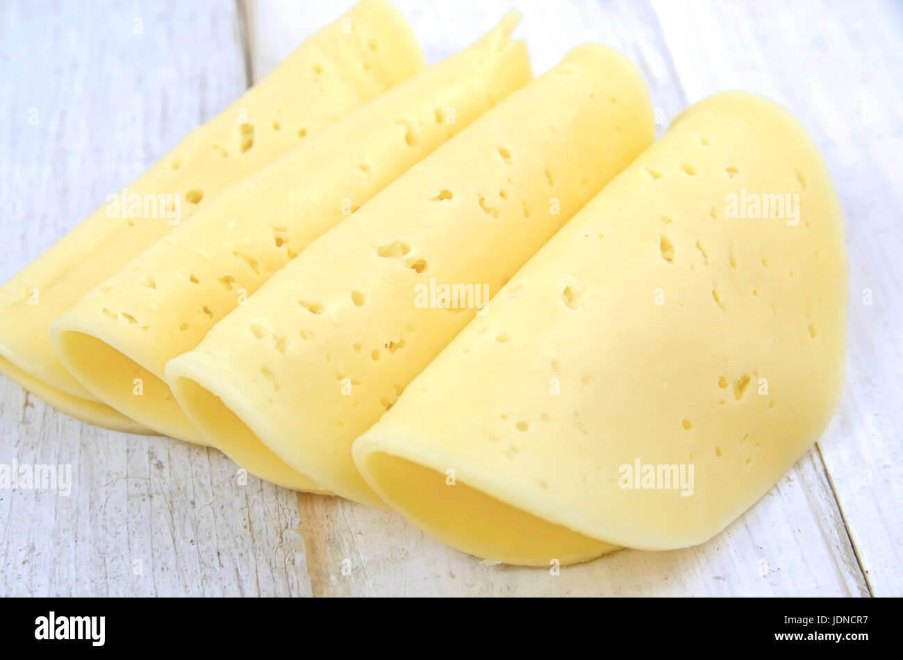 Stack of thin cheese pieces rounded Stock Photo - Alamy