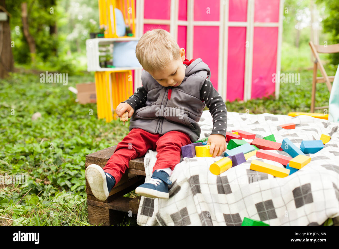 Little boy building something using wooden colorful toy block sitting ...