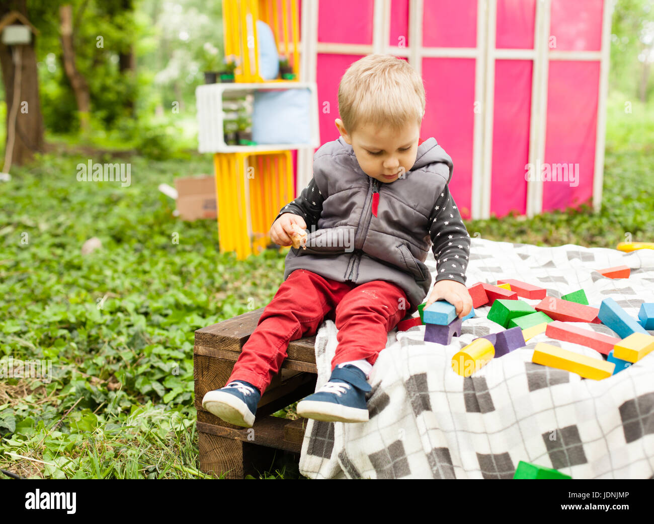 Little boy building something using wooden colorful toy block sitting ...