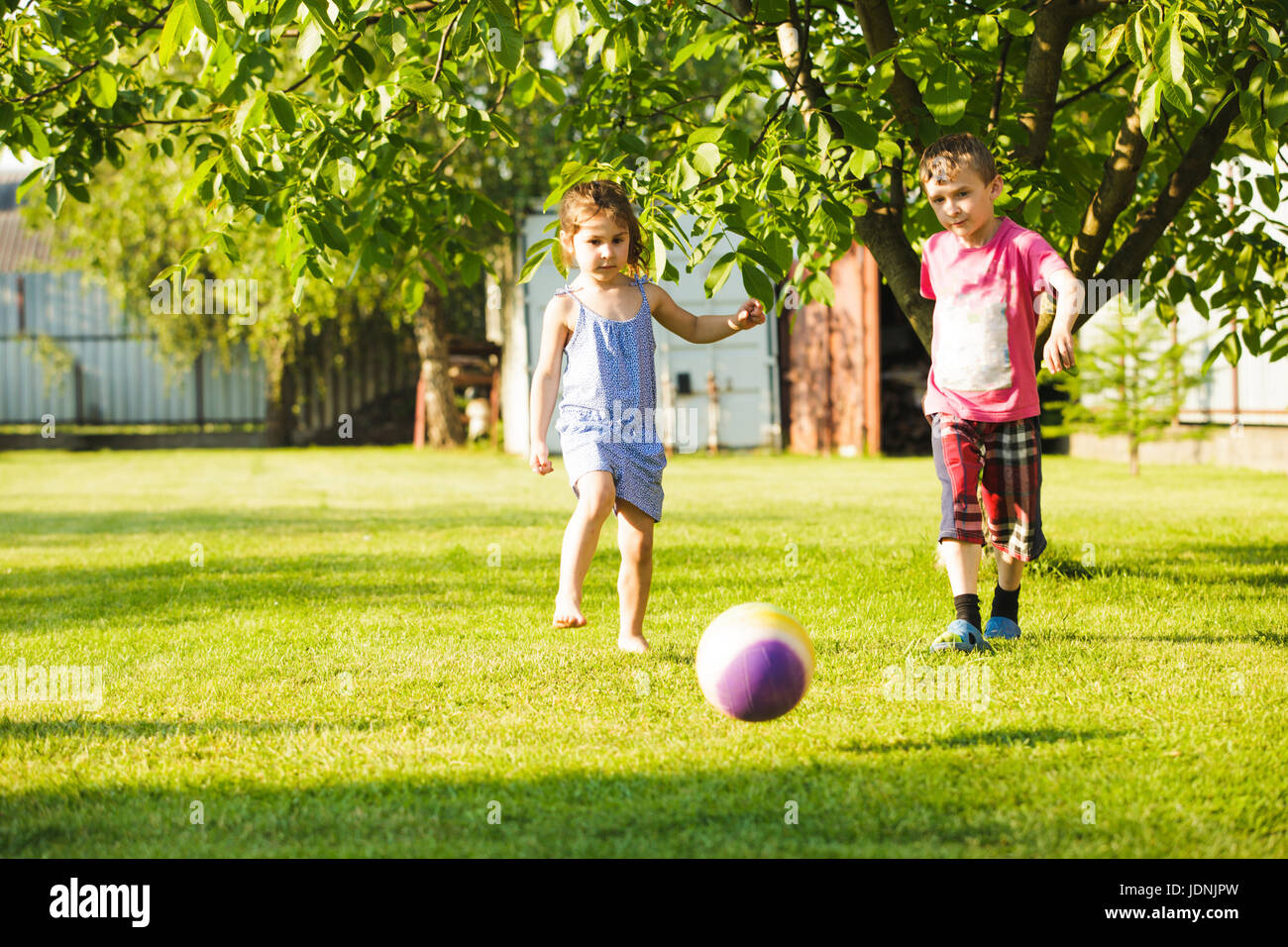 Children play with colorful ball in the rural backyard Stock Photo - Alamy