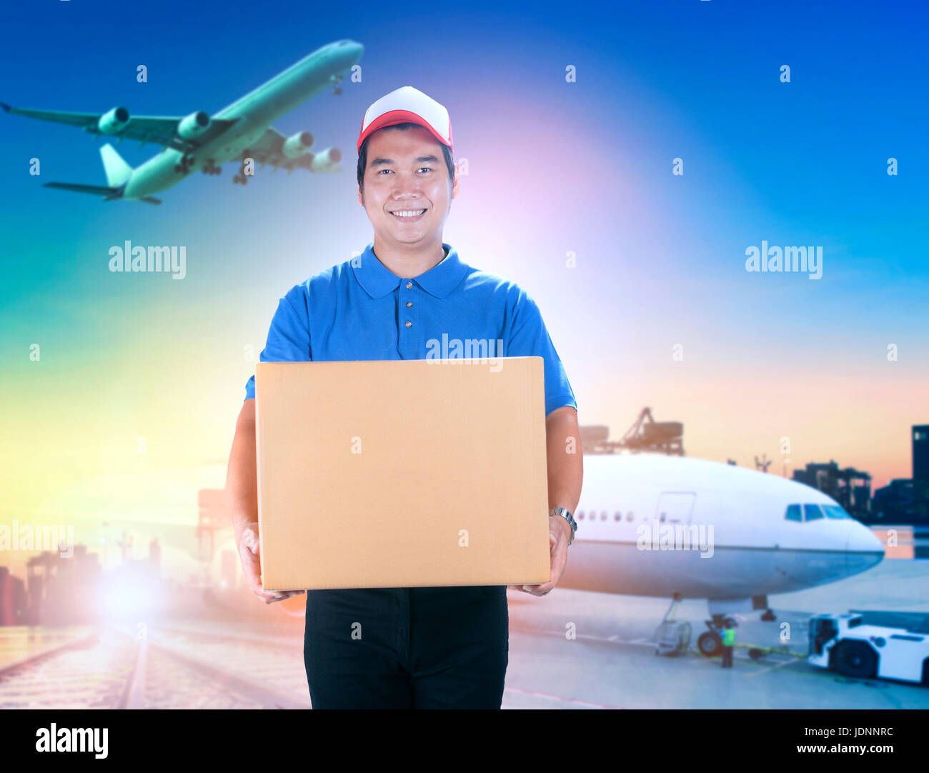 delivery man holding card box toothy smiling face against shipping port ...