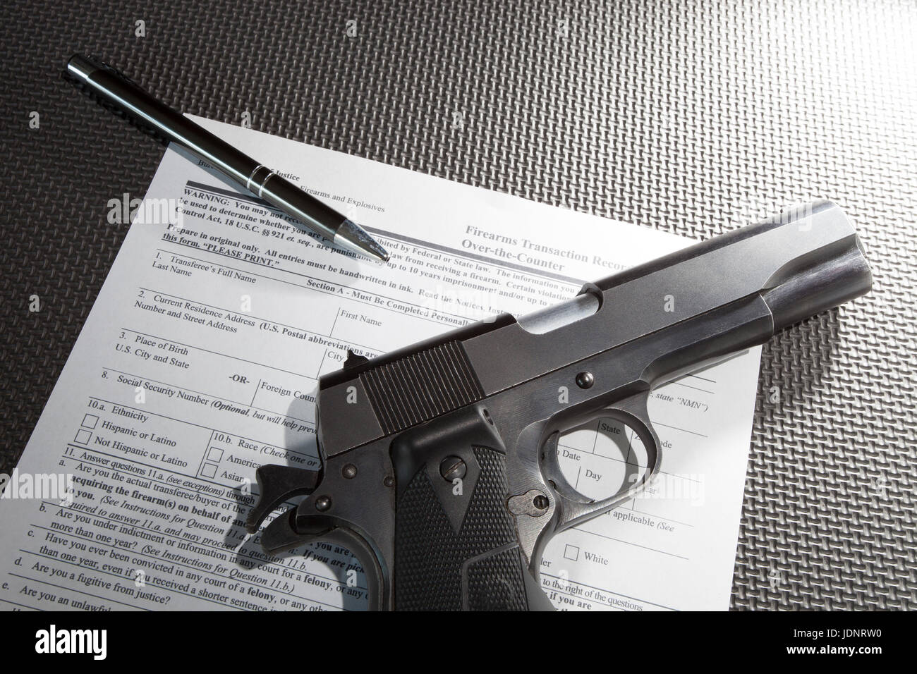 Pen and handgun with paperwork required to purchase the gun Stock Photo ...