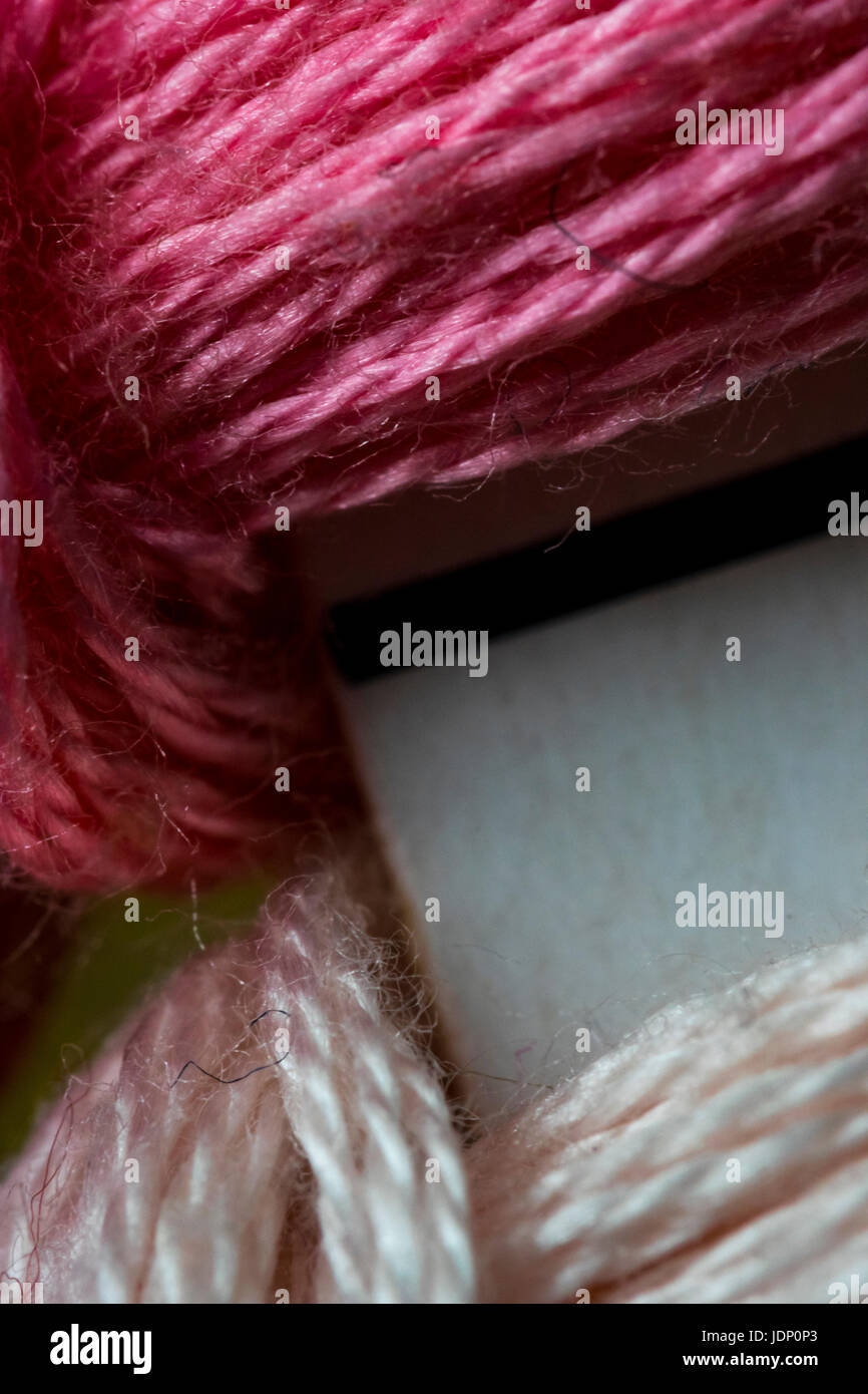 Pale pink and purple sewing threads pattern macro Stock Photo - Alamy