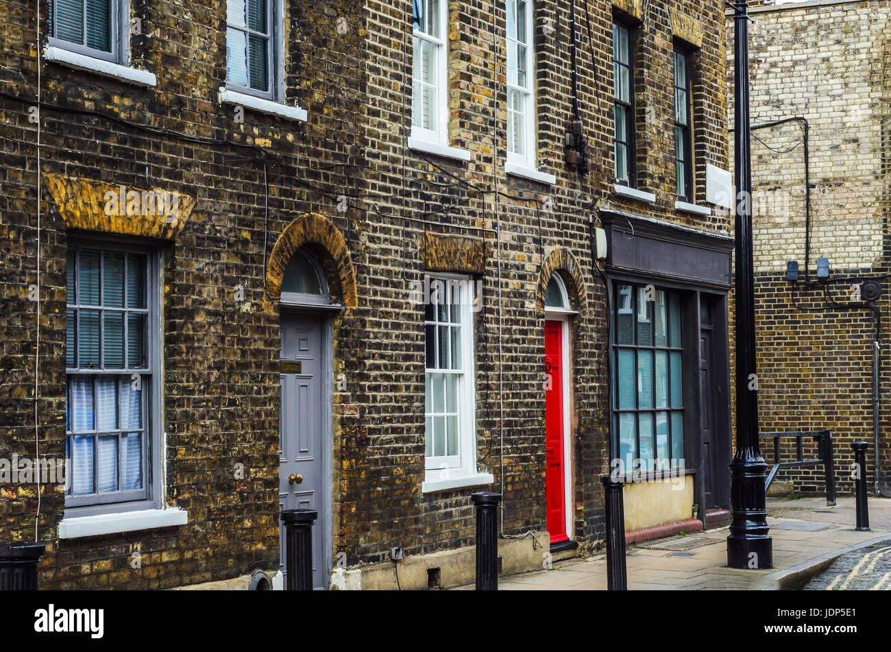 Typical old English buildings, low brick buildings across a narrow ...