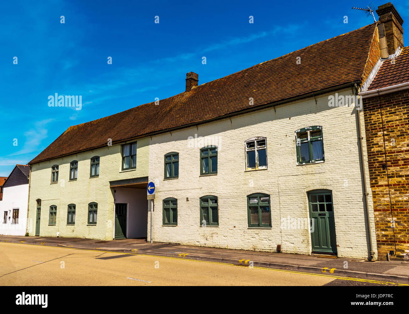 Typical old English buildings, low brick buildings across a narrow ...