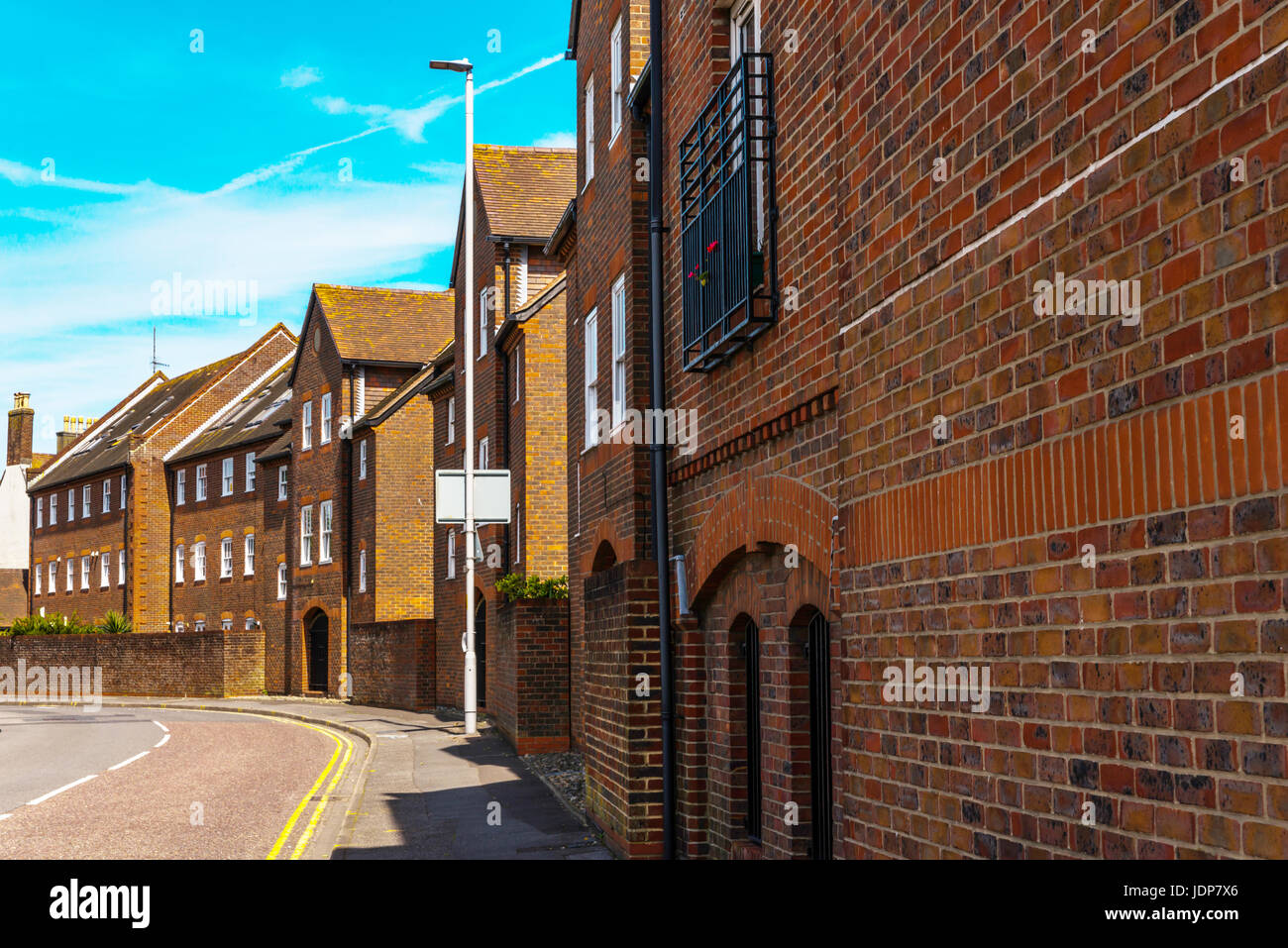 Typical old English buildings, low brick buildings across a narrow ...