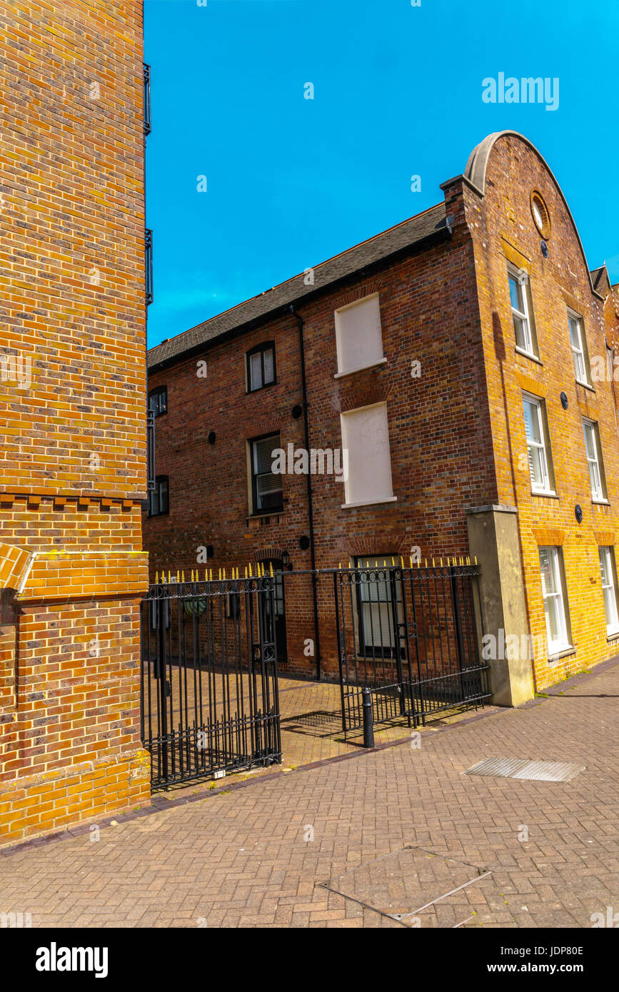 Typical old English buildings, low brick buildings across a narrow ...